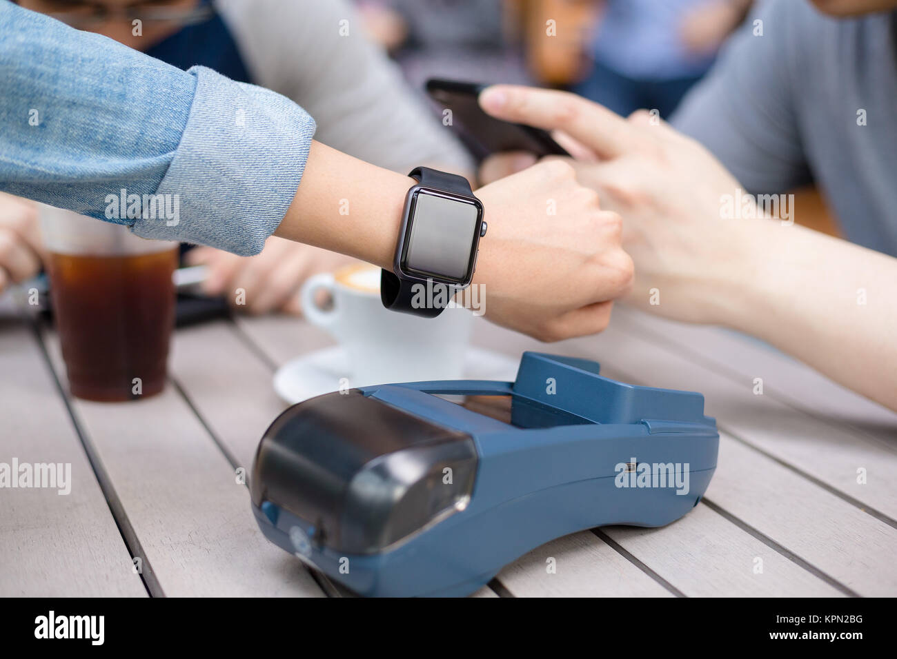 Woman pay by smart watch on pos machine Stock Photo - Alamy