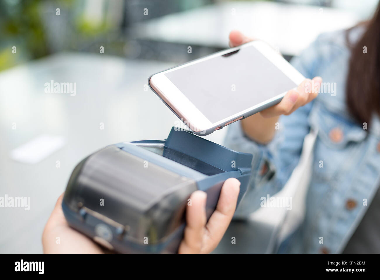 Woman using cellphone to pay with NFC technology Stock Photo - Alamy