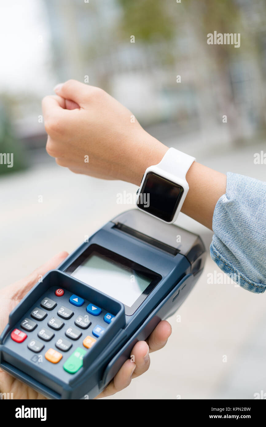 Customer using smart watch to checkout Stock Photo - Alamy