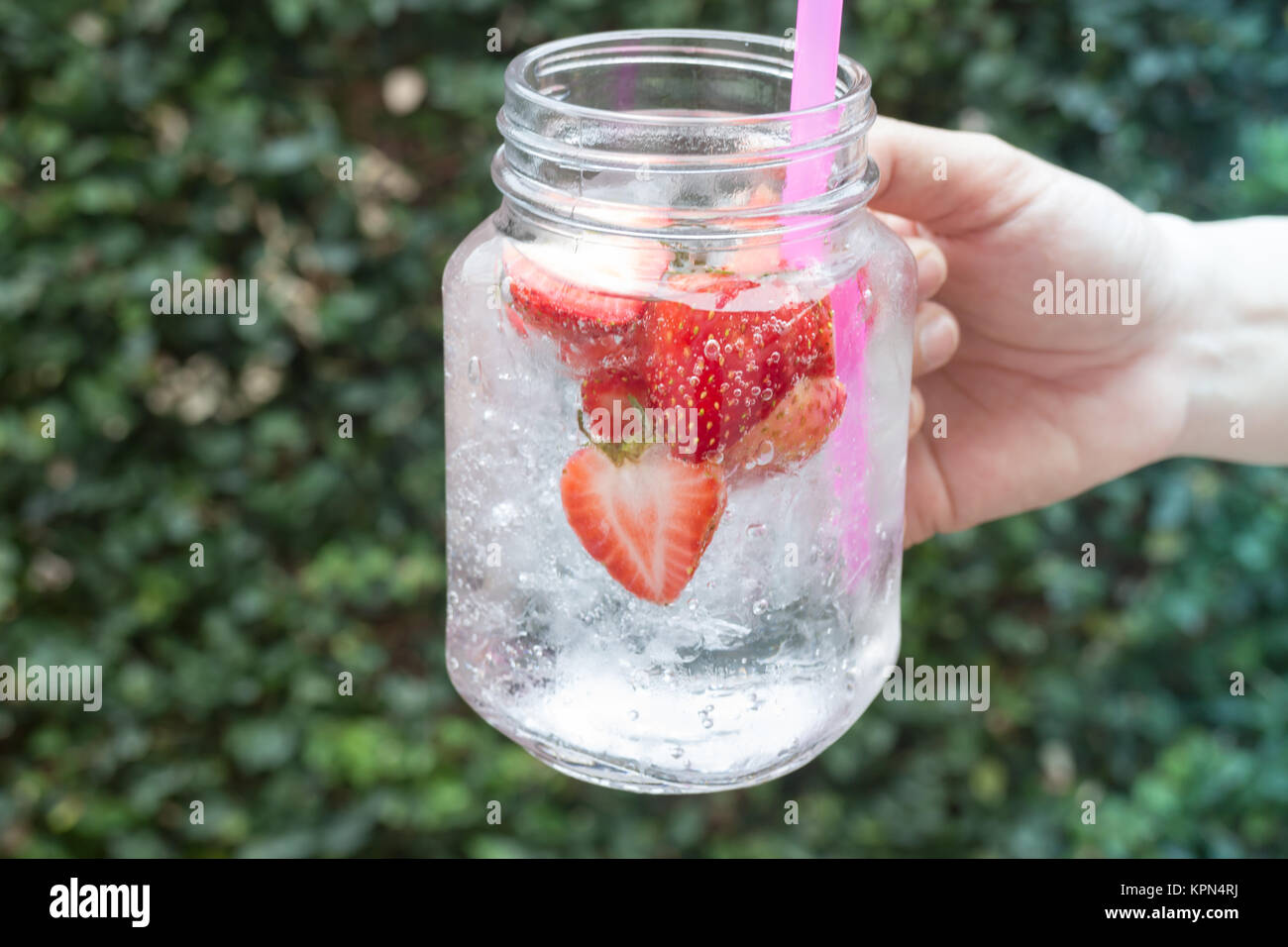 Hand hold glass of iced strawberry soda drink Stock Photo - Alamy