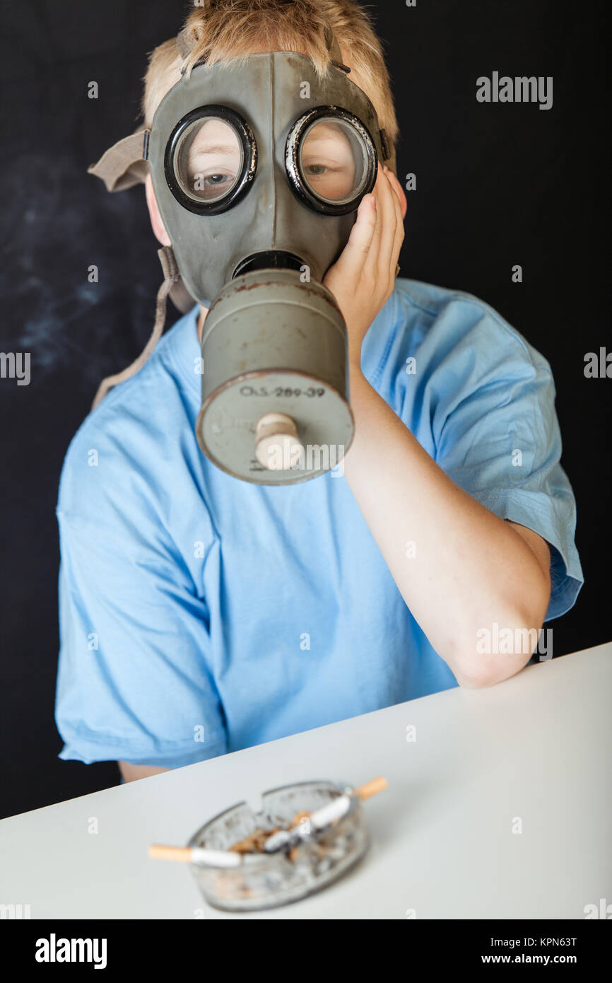 Cigarettes in front of sad child in gas mask Stock Photo - Alamy