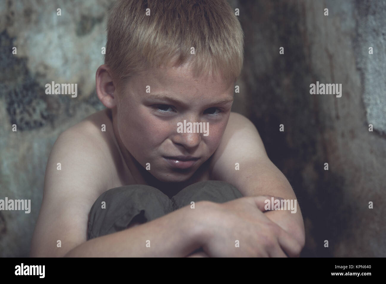 Weeping boy curled up in corner Stock Photo - Alamy
