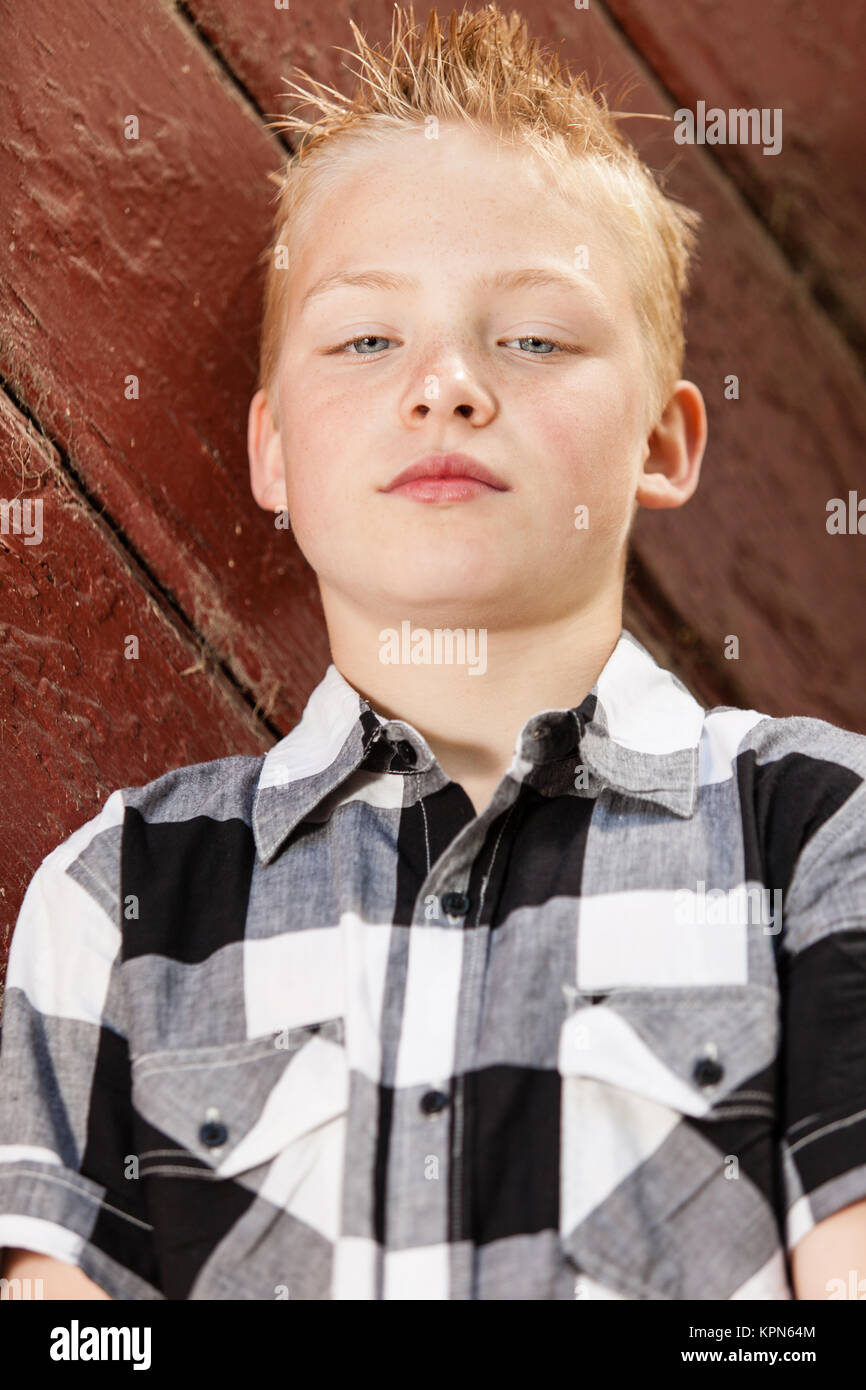 Handsome little boy leaning against wall Stock Photo - Alamy