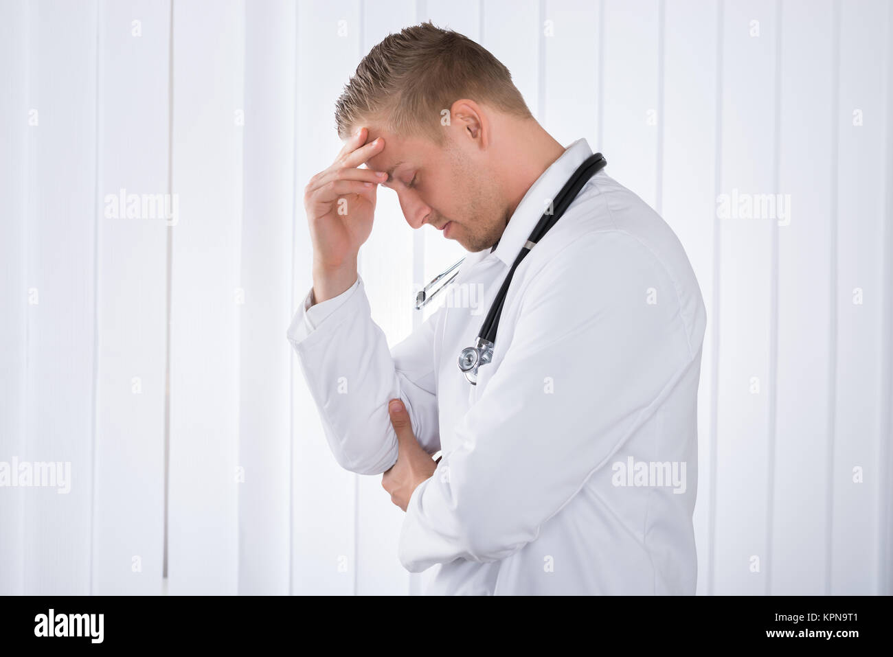 Sad Doctor Standing In Clinic Stock Photo - Alamy