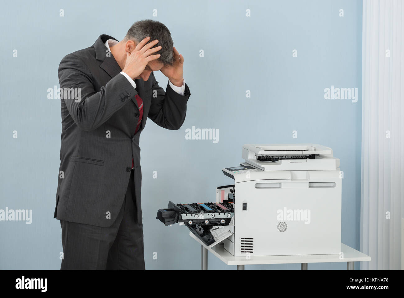 Businessman Looking At Printer Machine At Office Stock Photo - Alamy
