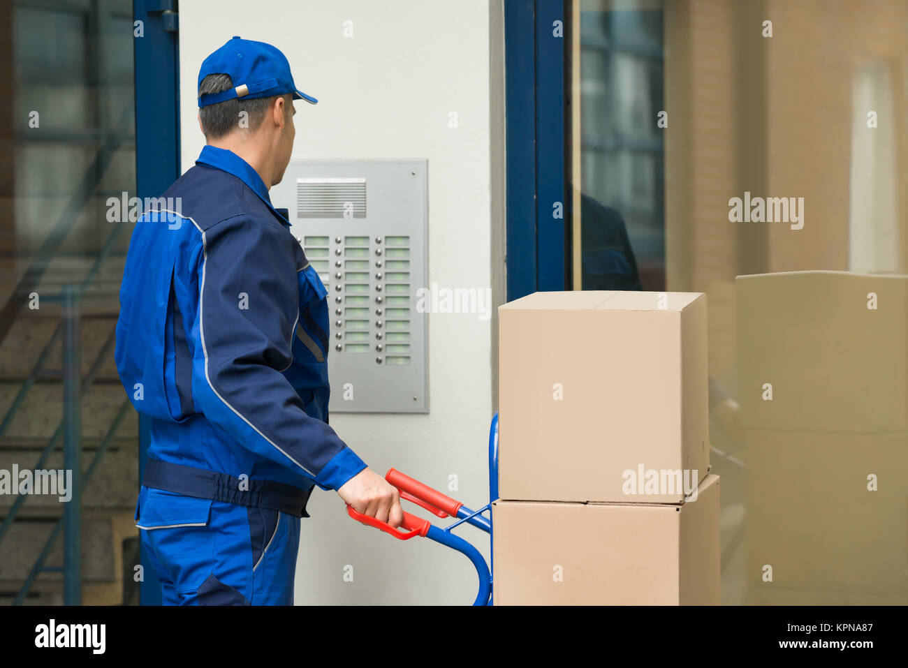 Delivery Man With Trolley Using Security To Enter Building Stock Photo ...