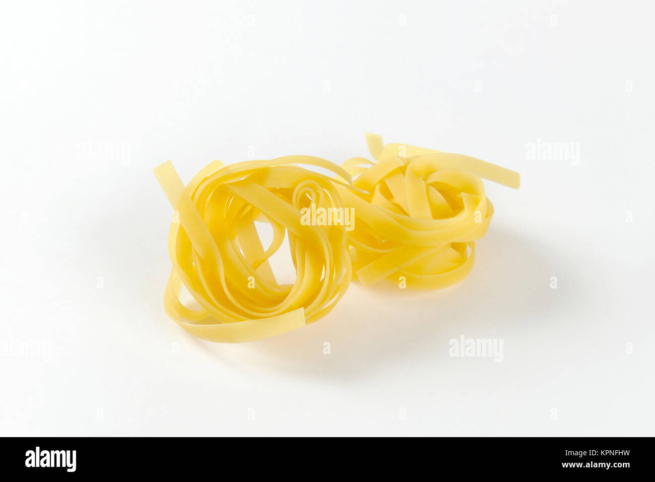 Nests of dry pasta tagliatelle Stock Photo - Alamy
