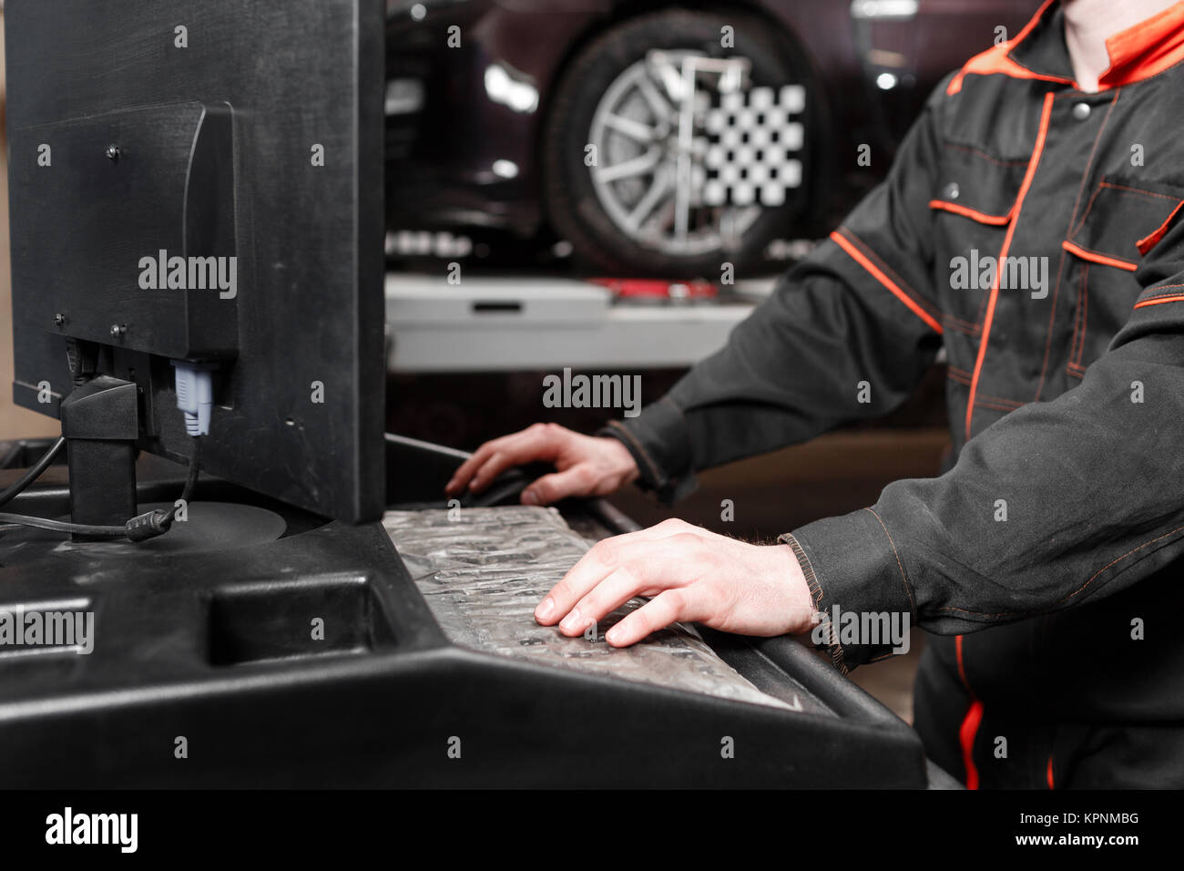 auto mechanic performs diagnostics and configuration on the computer ...
