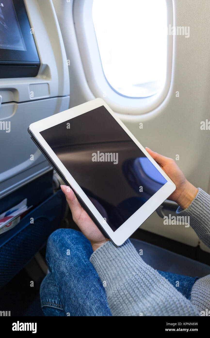 Woman use of tablet pc inside aircraft Stock Photo - Alamy