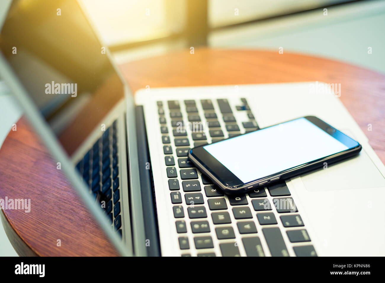 Laptop computer and cellphone on table Stock Photo - Alamy