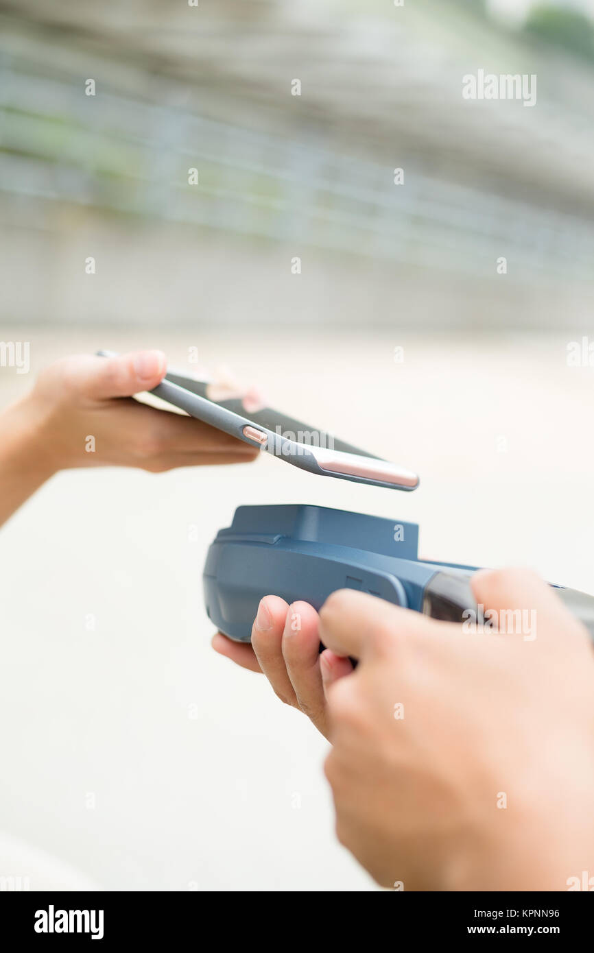 Customer using mobile phone on pos machine Stock Photo - Alamy
