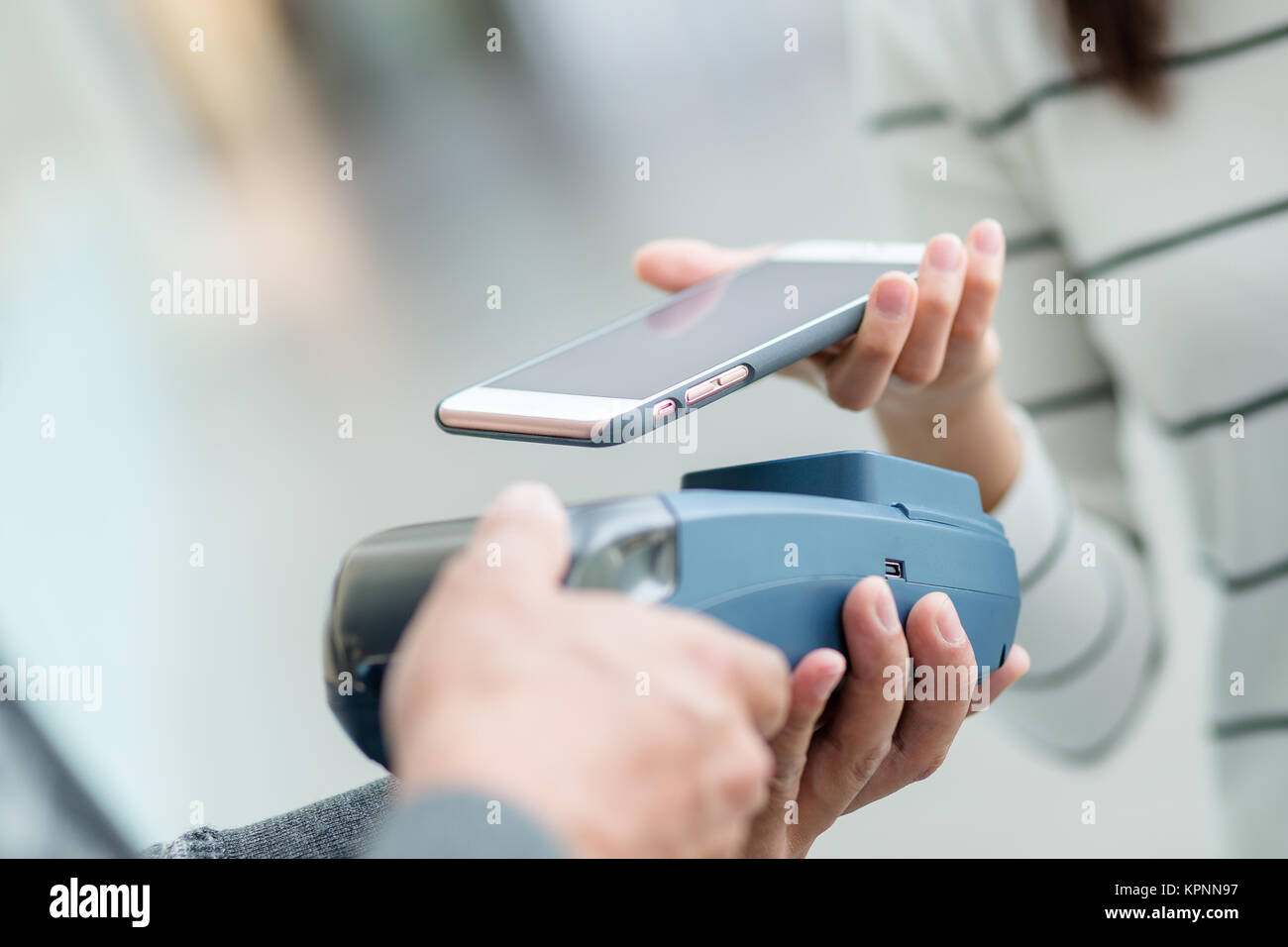 Woman using mobile phone for paying Stock Photo - Alamy