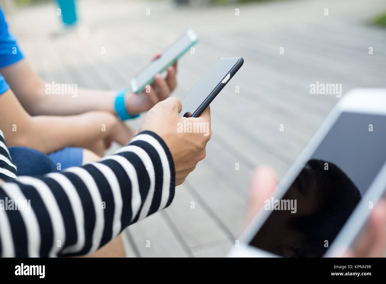 Group of people using smartphone together Stock Photo - Alamy