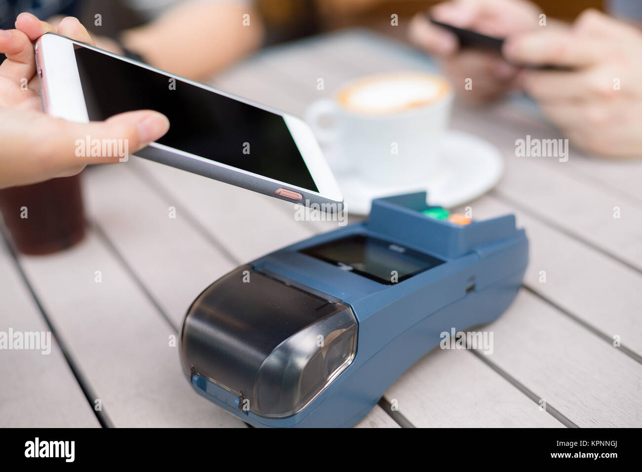 Customer pay by cellphone on pos machine Stock Photo - Alamy