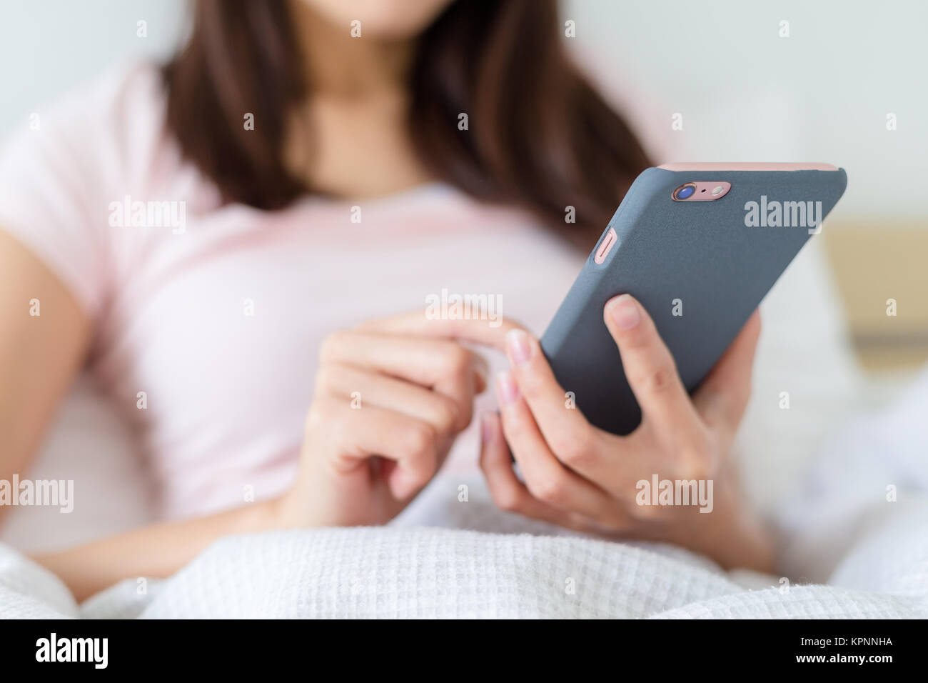 Woman use of mobile phone on bed Stock Photo - Alamy
