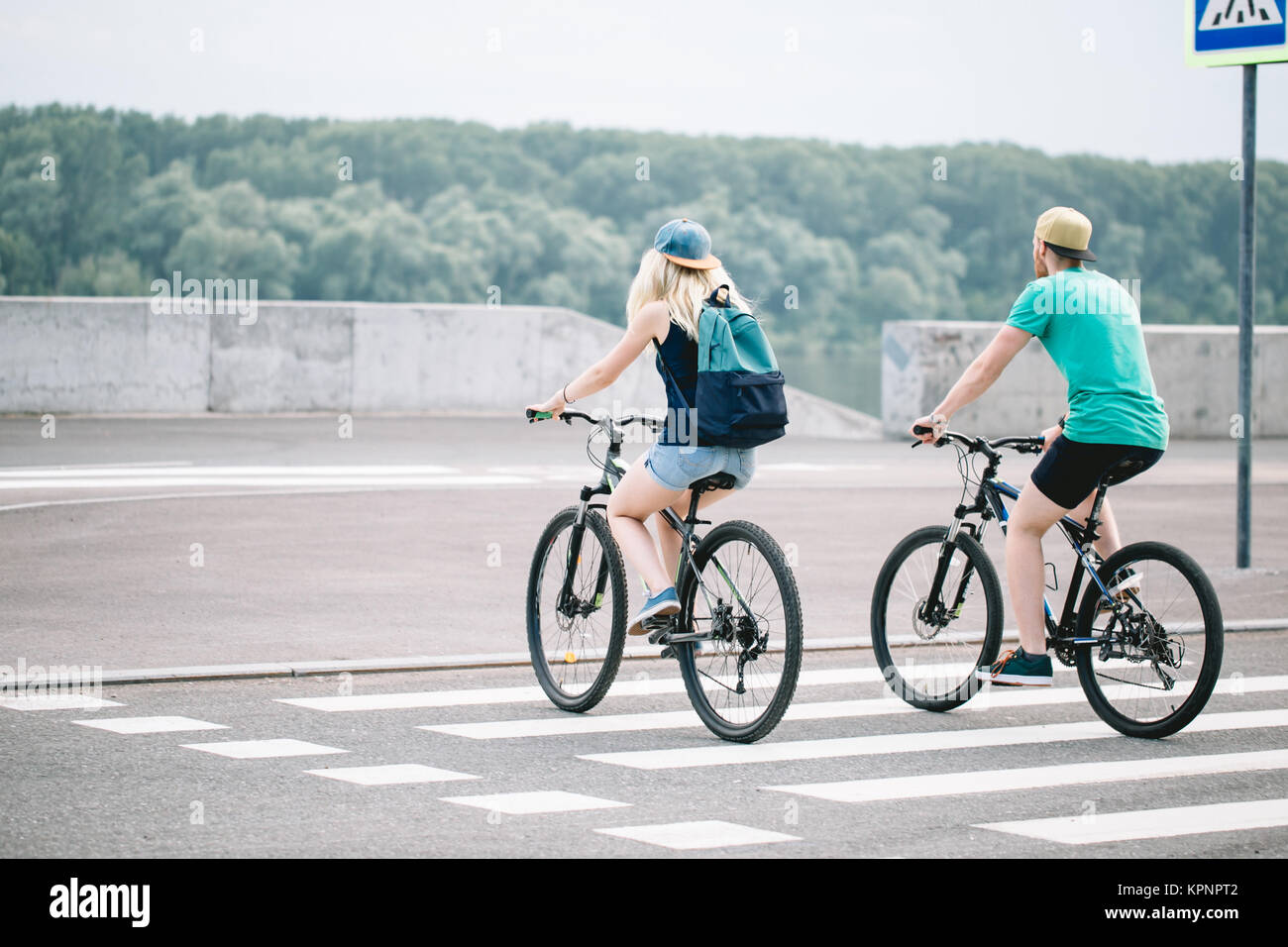 Young sporty couple riding on bicycle. Rear view Stock Photo - Alamy