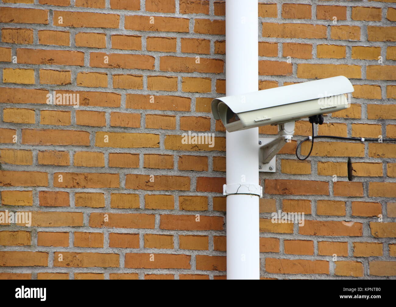 Surveillance Camera mounted on Yellow Brick Wall Stock Photo - Alamy