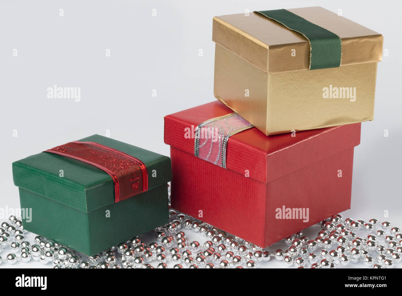 Three presents with ribbons, gold, green and red, isolated Stock Photo ...