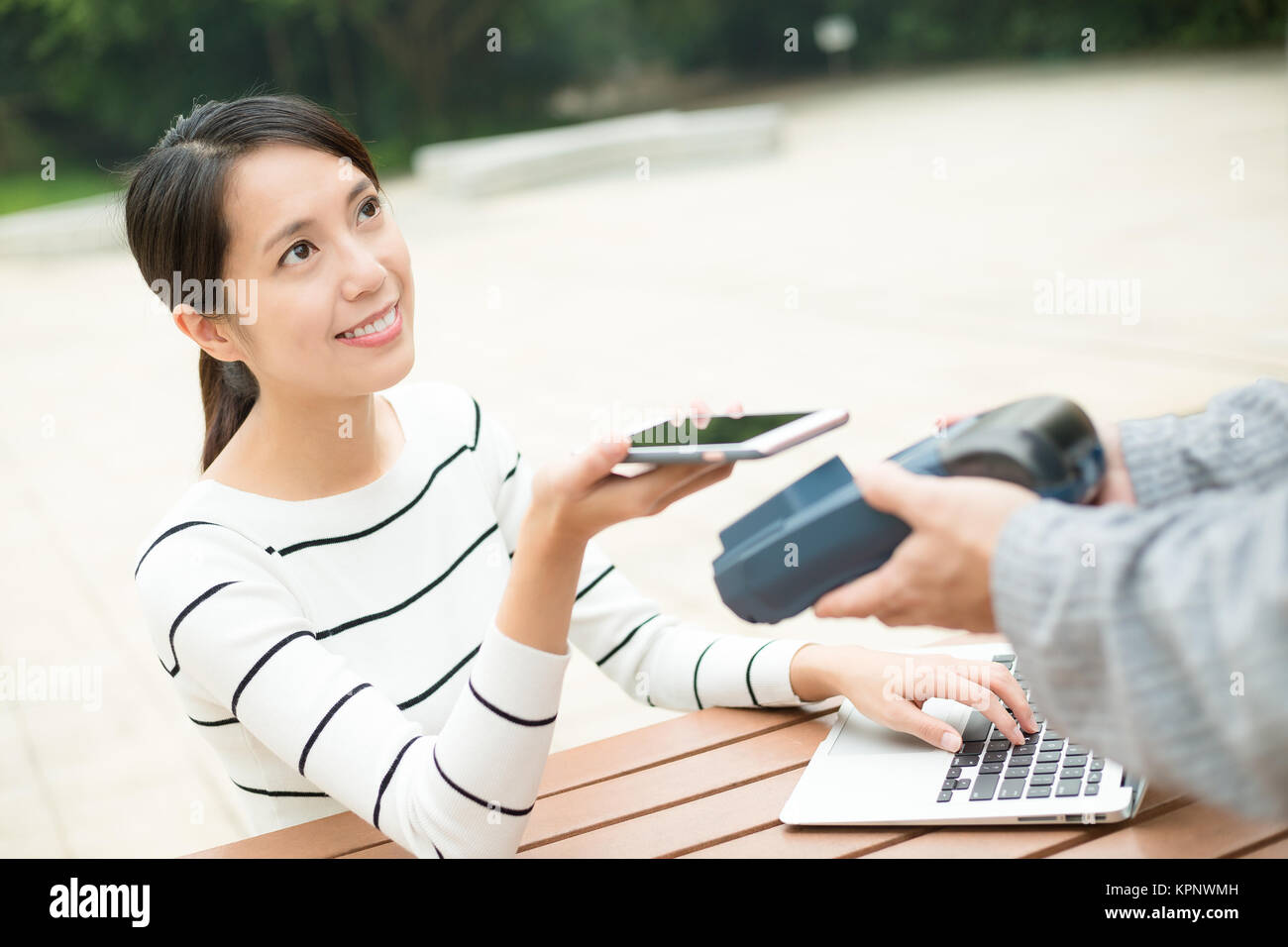 Woman paying by mobile phone with NFC technology Stock Photo - Alamy