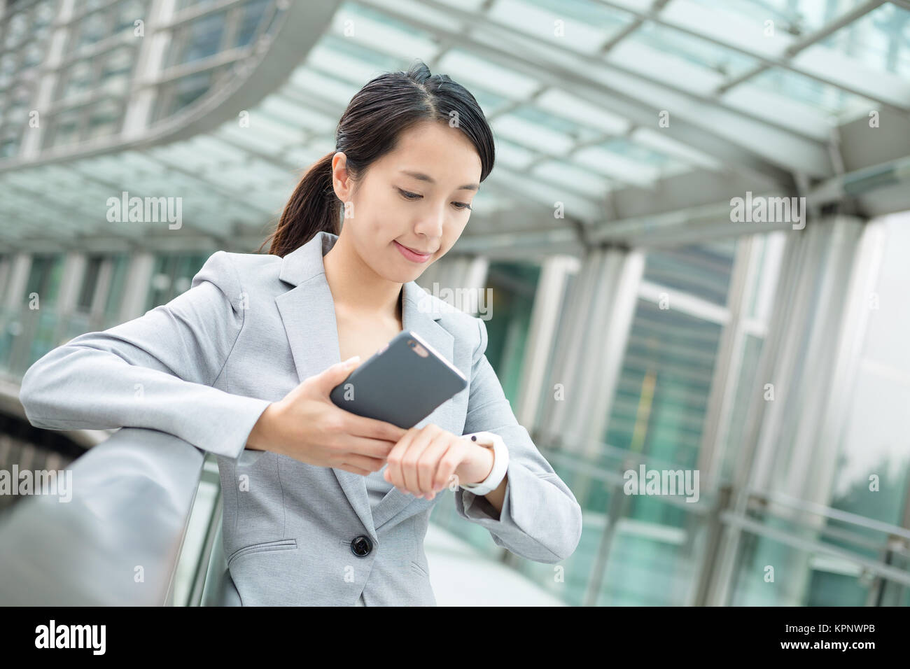 Business woman connecting smart watch and cellphone Stock Photo - Alamy