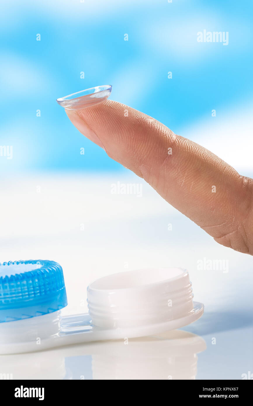 Contact lens on finger tip blue background Stock Photo - Alamy