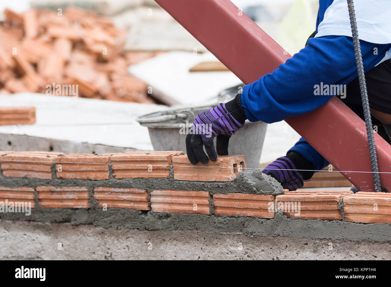 Bricklayer working in construction site of a brick wall Stock Photo - Alamy