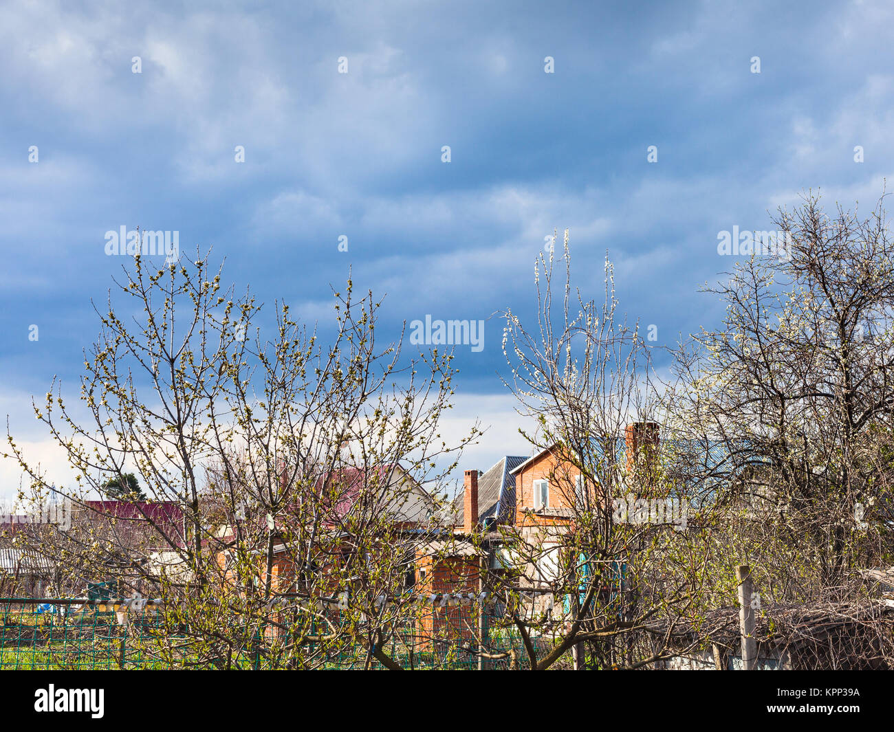 clouds over country houses and cherry trees Stock Photo - Alamy