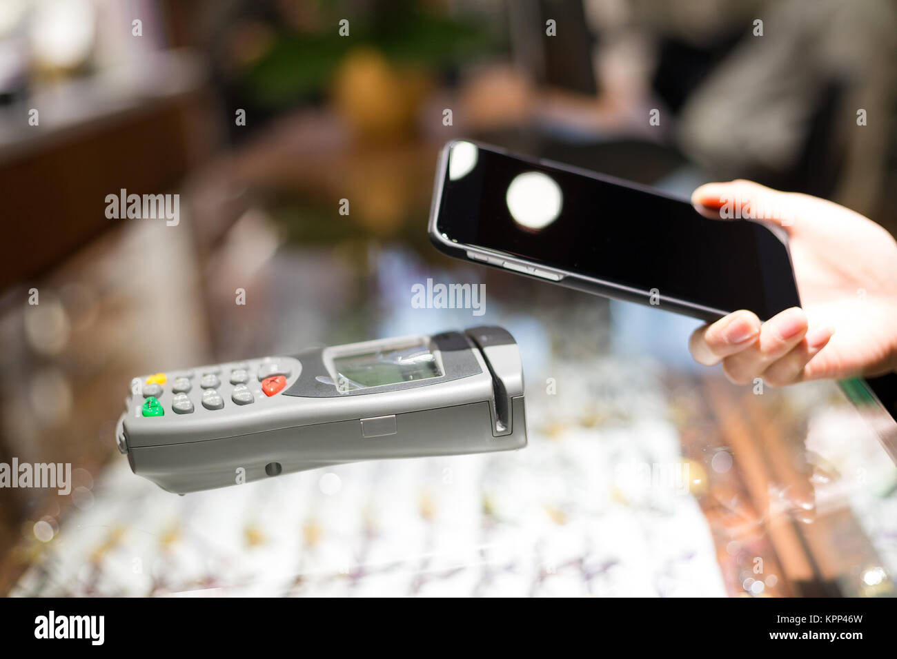 Woman pay bill on mobile phone by NFC Stock Photo - Alamy