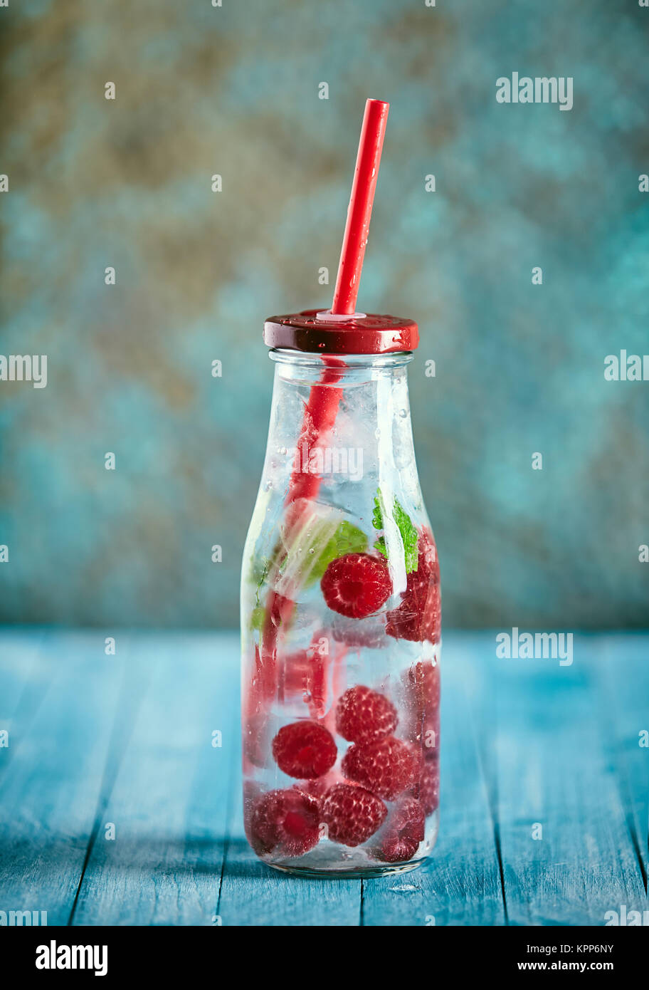 Single centered bottled beverage made from raspberry and mint with ...