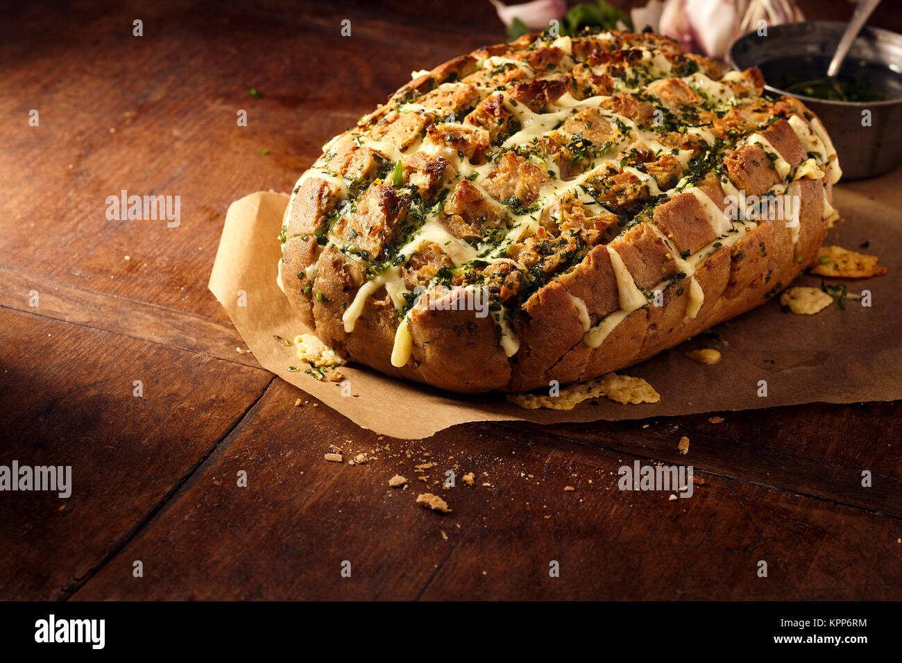 Tasty loaf of party bread dripping with melted cheese and herbs on ...