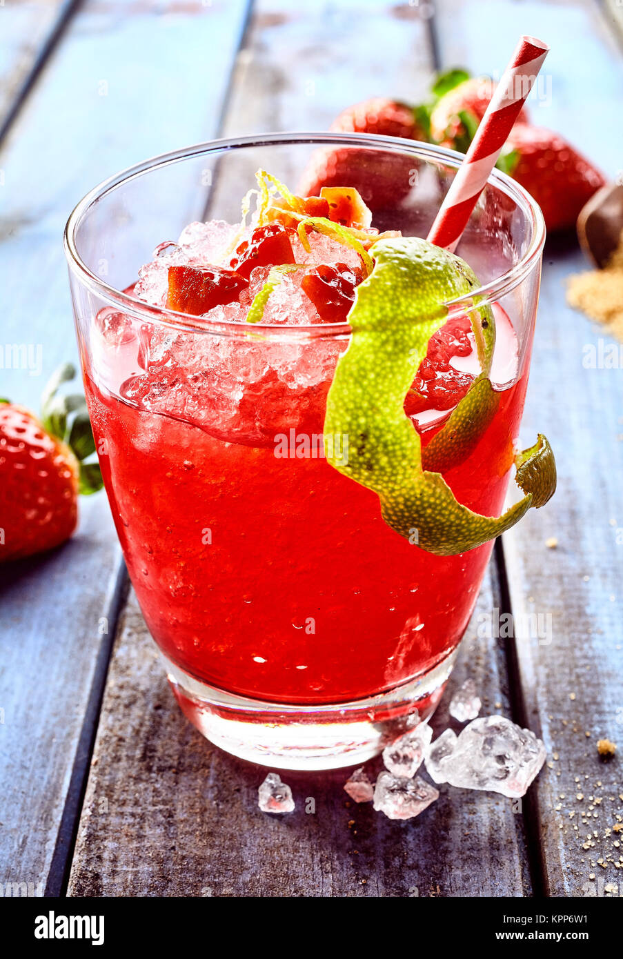 Single serving of red ice slush beverage in glass with red and white ...
