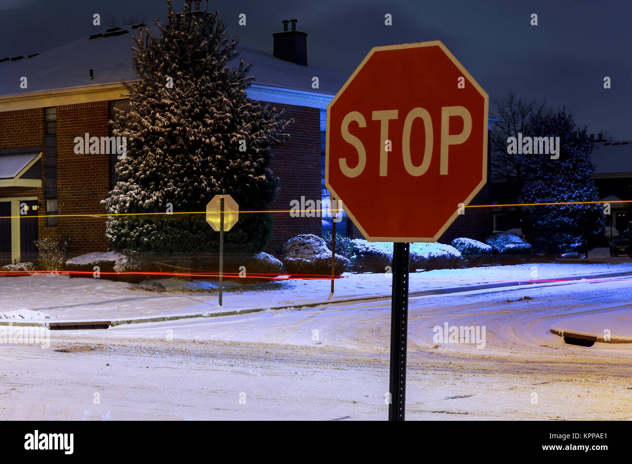 stop sign in winter snowing Night covered winter road with shining ...