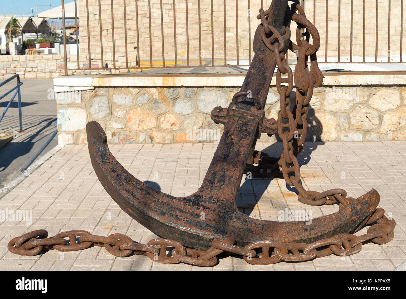 Old anchor is lying on the rocks near the port on the island of Crete ...