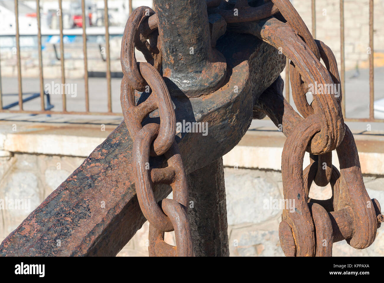 Old anchor is lying on the rocks near the port on the island of Crete ...