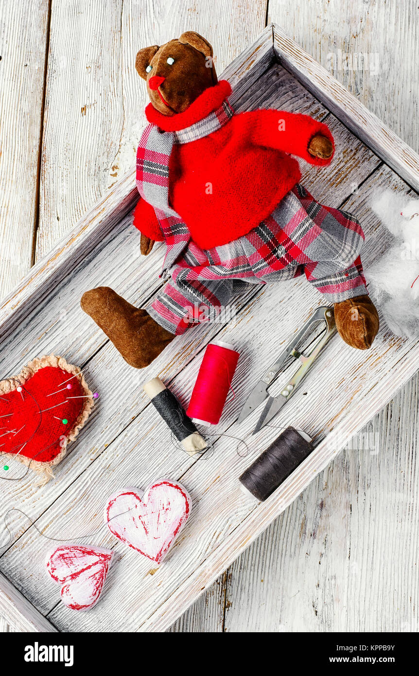 Soft toy teddy bear in clothes and sewing equipment Stock Photo - Alamy