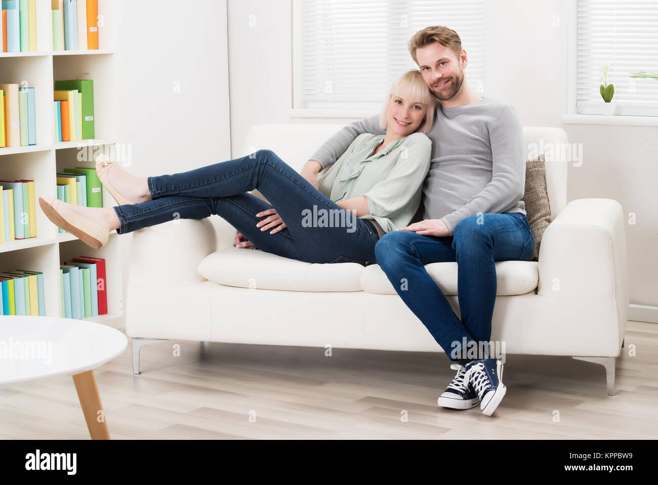 Smiling Couple Relaxing On Sofa Stock Photo - Alamy