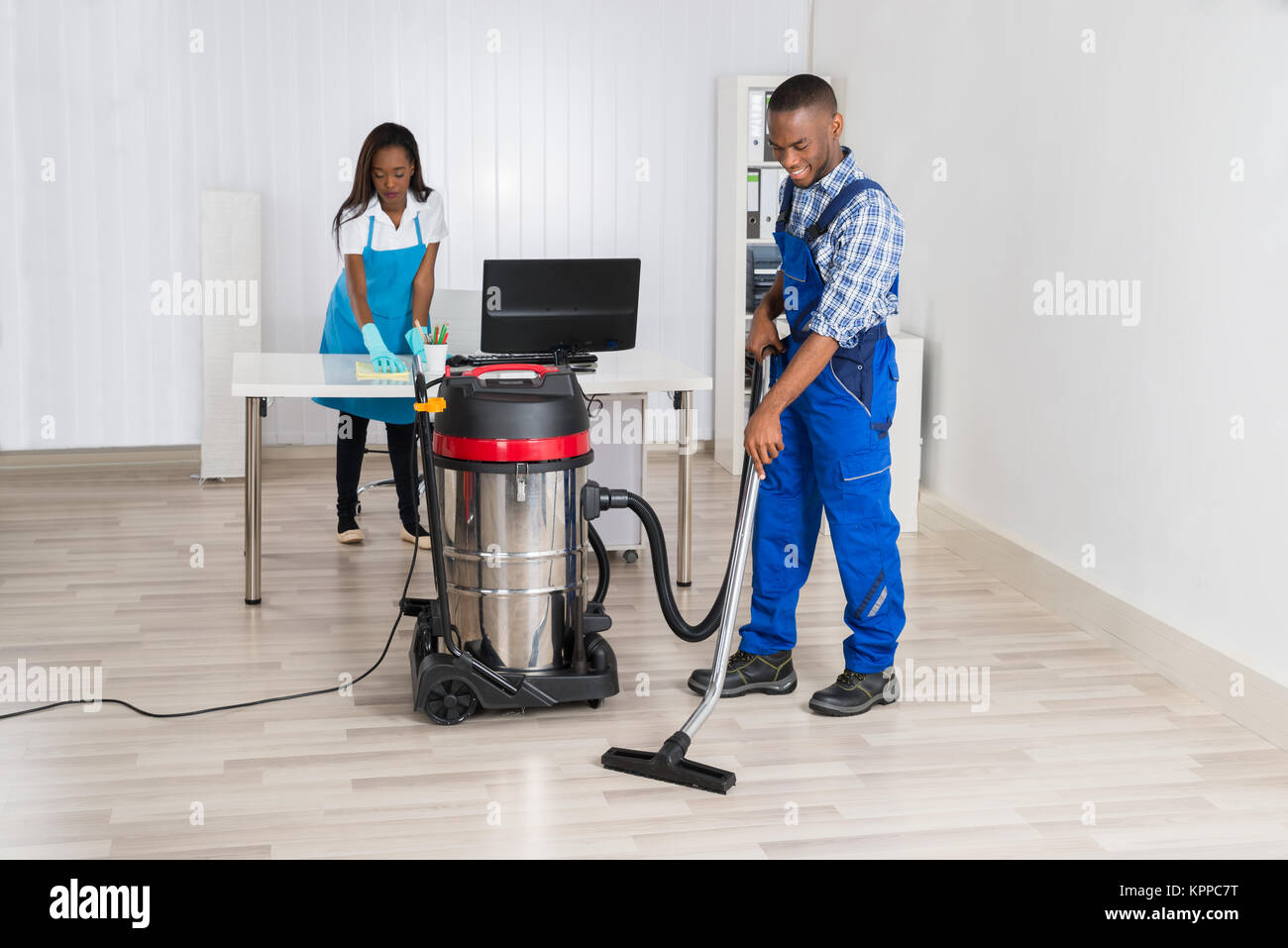 Male And Female Janitor Cleaning Office Stock Photo - Alamy