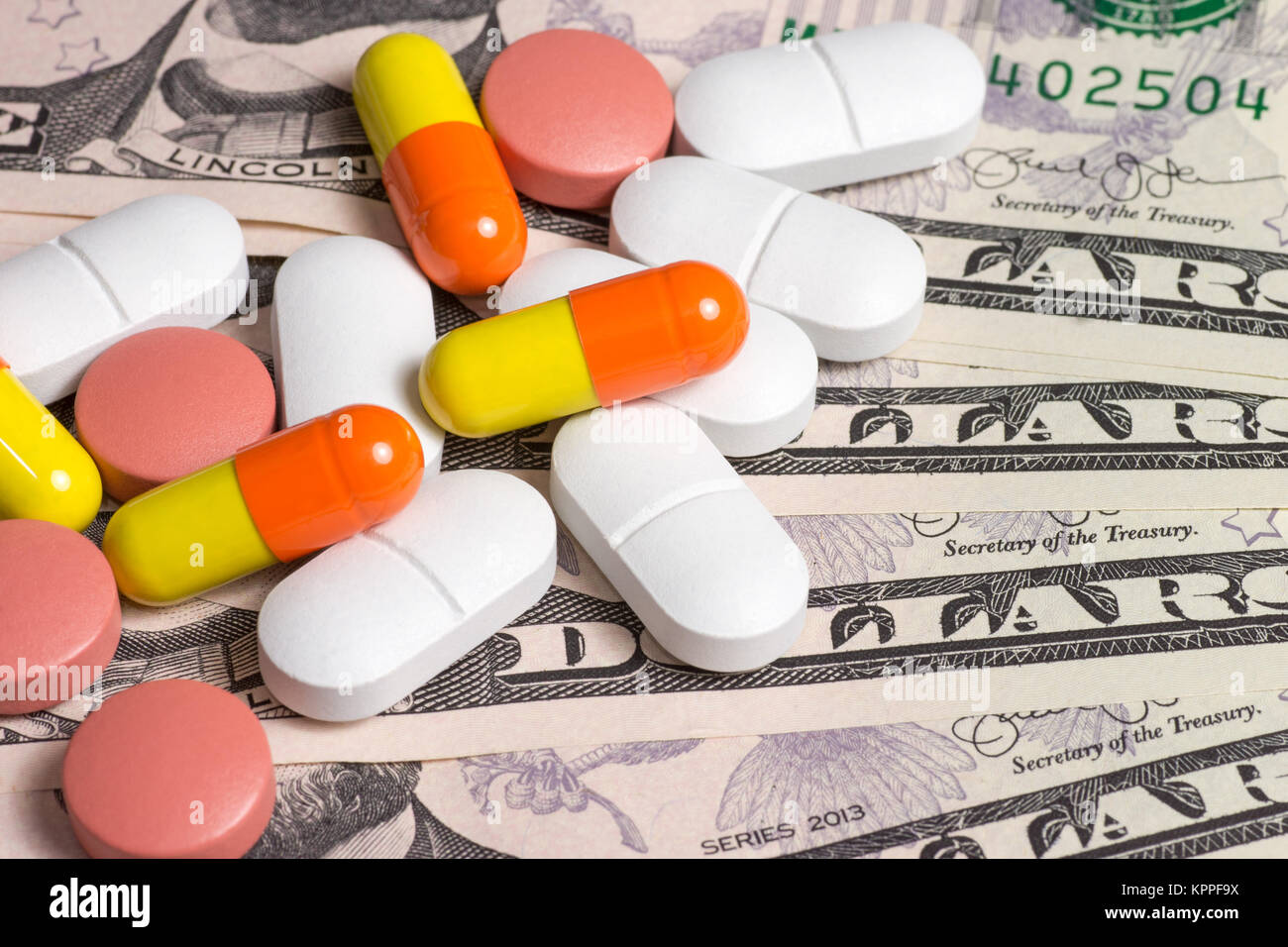 Medicines capsules and pills on dollar bills Stock Photo - Alamy