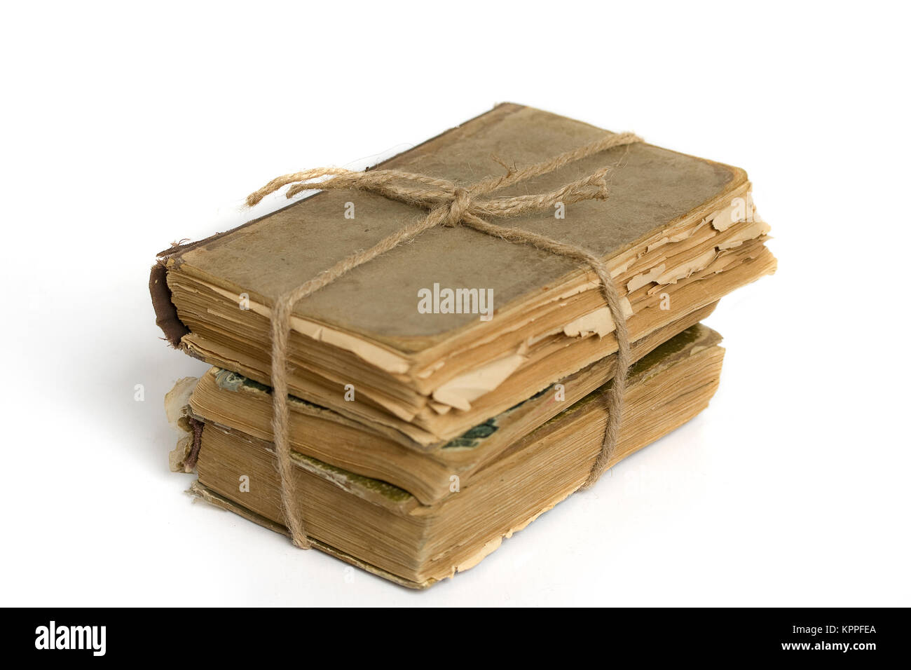 a stack of shabby old books tied with string on white background Stock ...