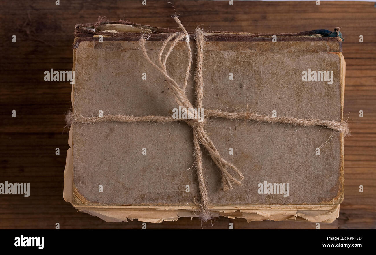 a shabby old book tied with string on a rough wooden background Stock ...