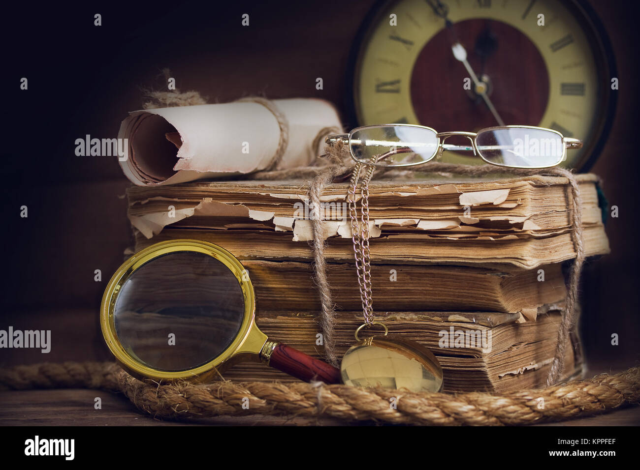 a still life with old scruffy books reading glasses, a clock and a ...