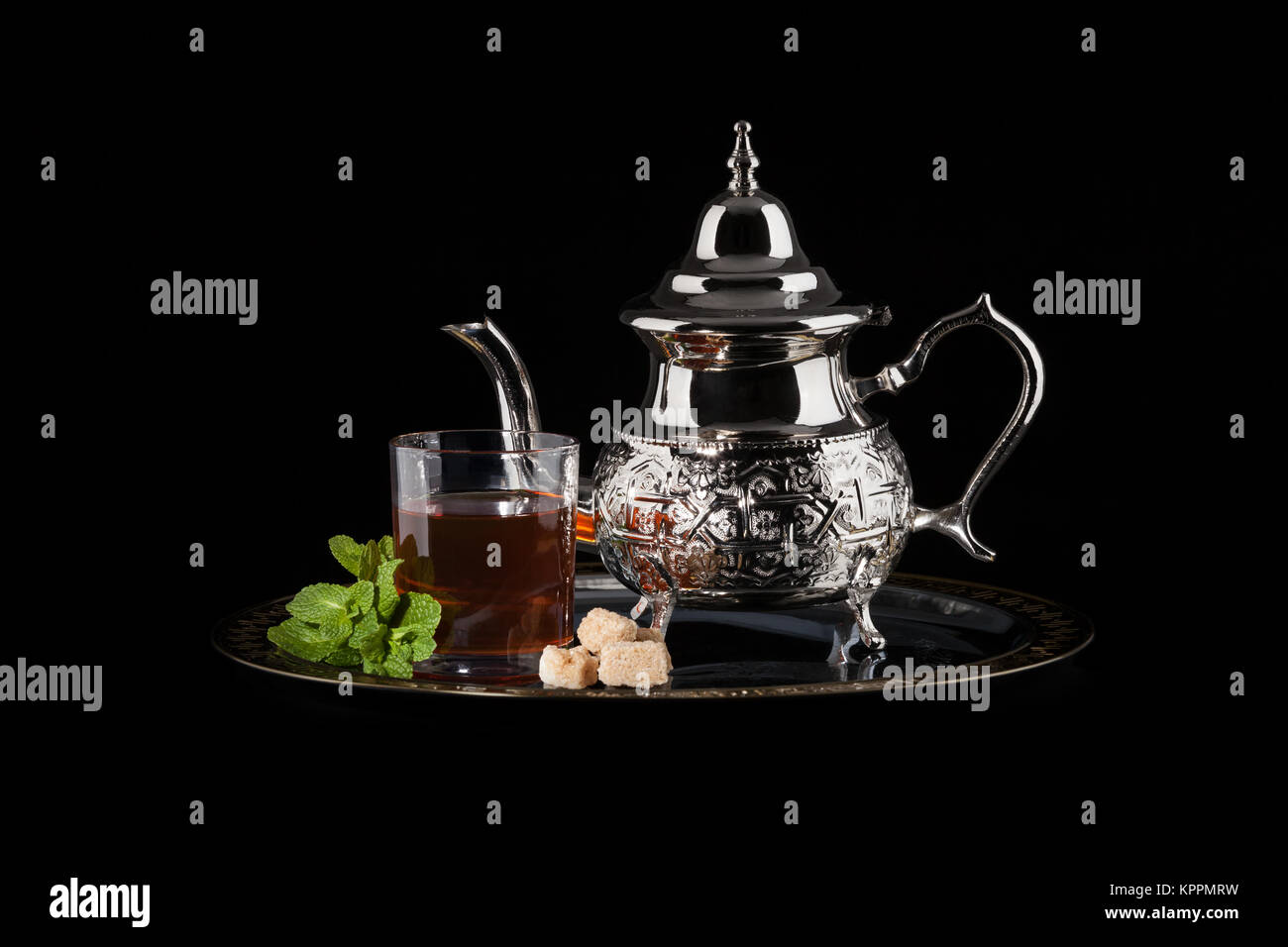 Traditional moroccan teapot with glass of green tea isolated on black ...