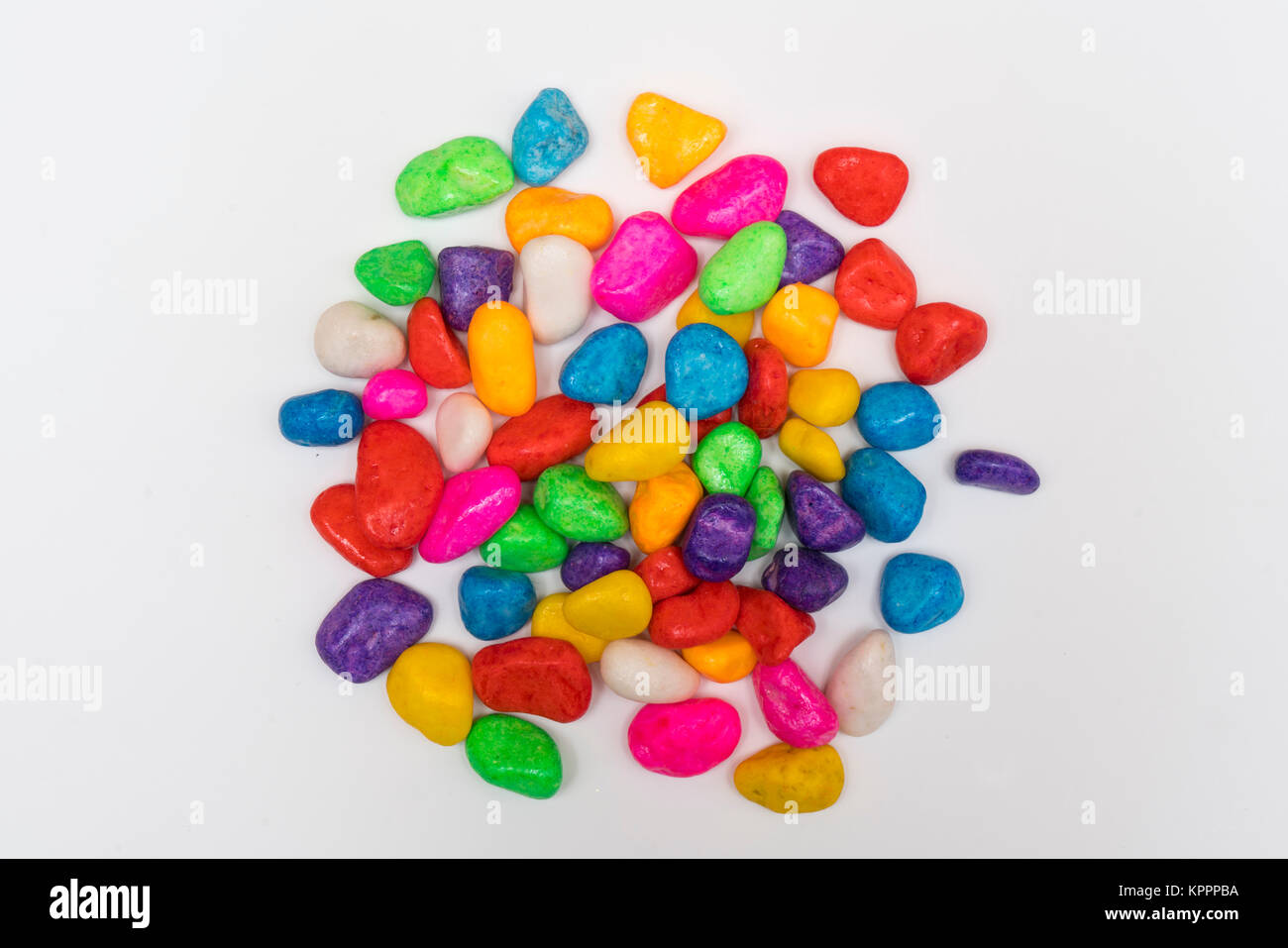 small colored pebbles on a white background Stock Photo - Alamy