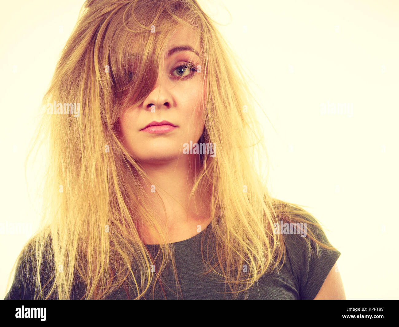 Bad hairstyle concept. Sad blonde woman with messy hair looking tired ...