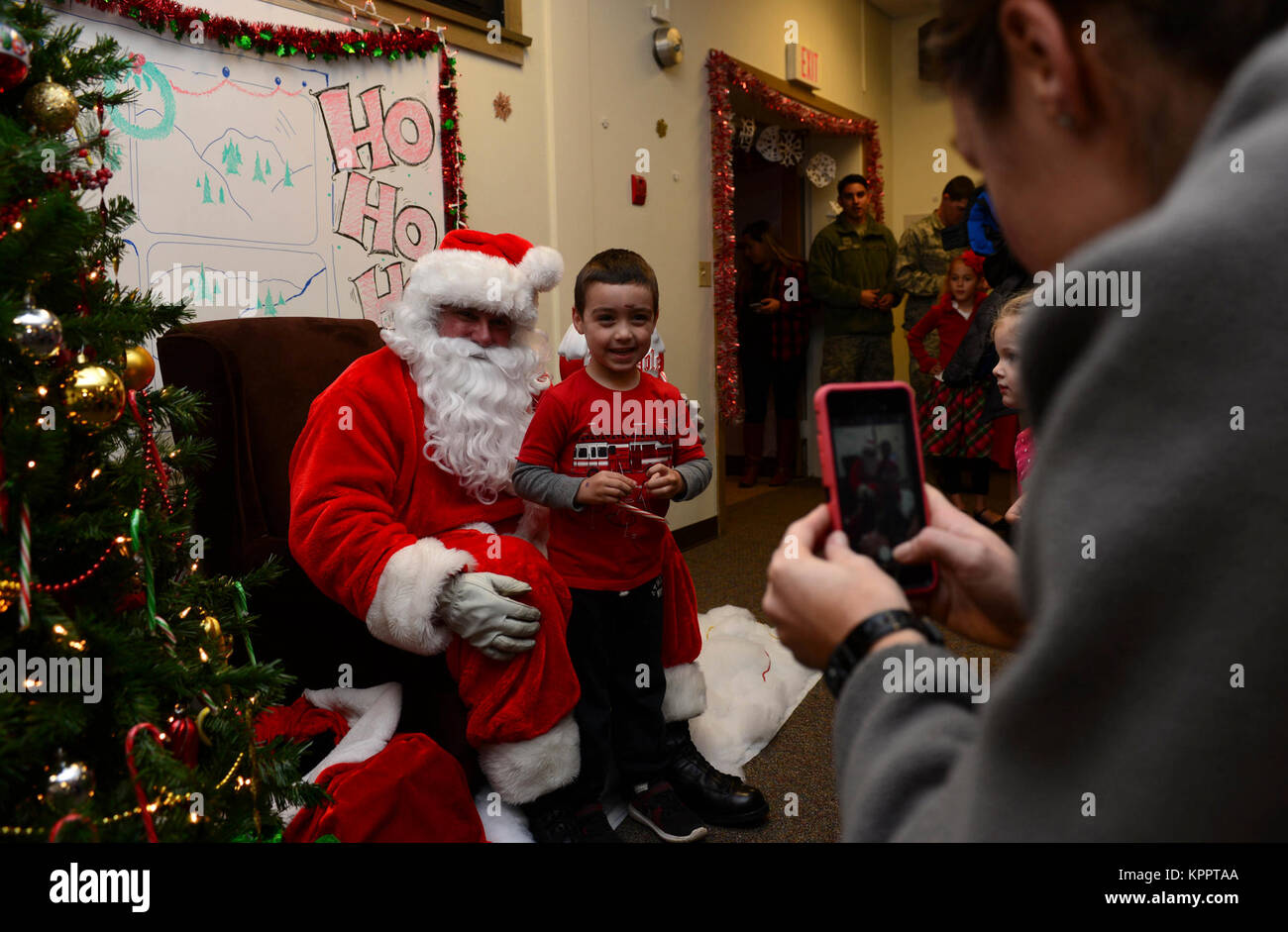 Children line up to meet Santa Claus and tell him what they want for ...
