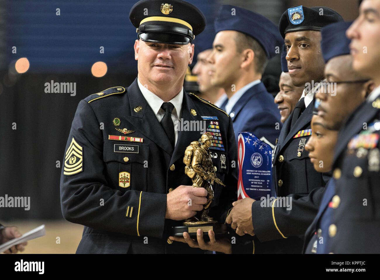 Command Sgt. Maj. Michael F. Brooks prepares to hand a trophy to Sgt ...