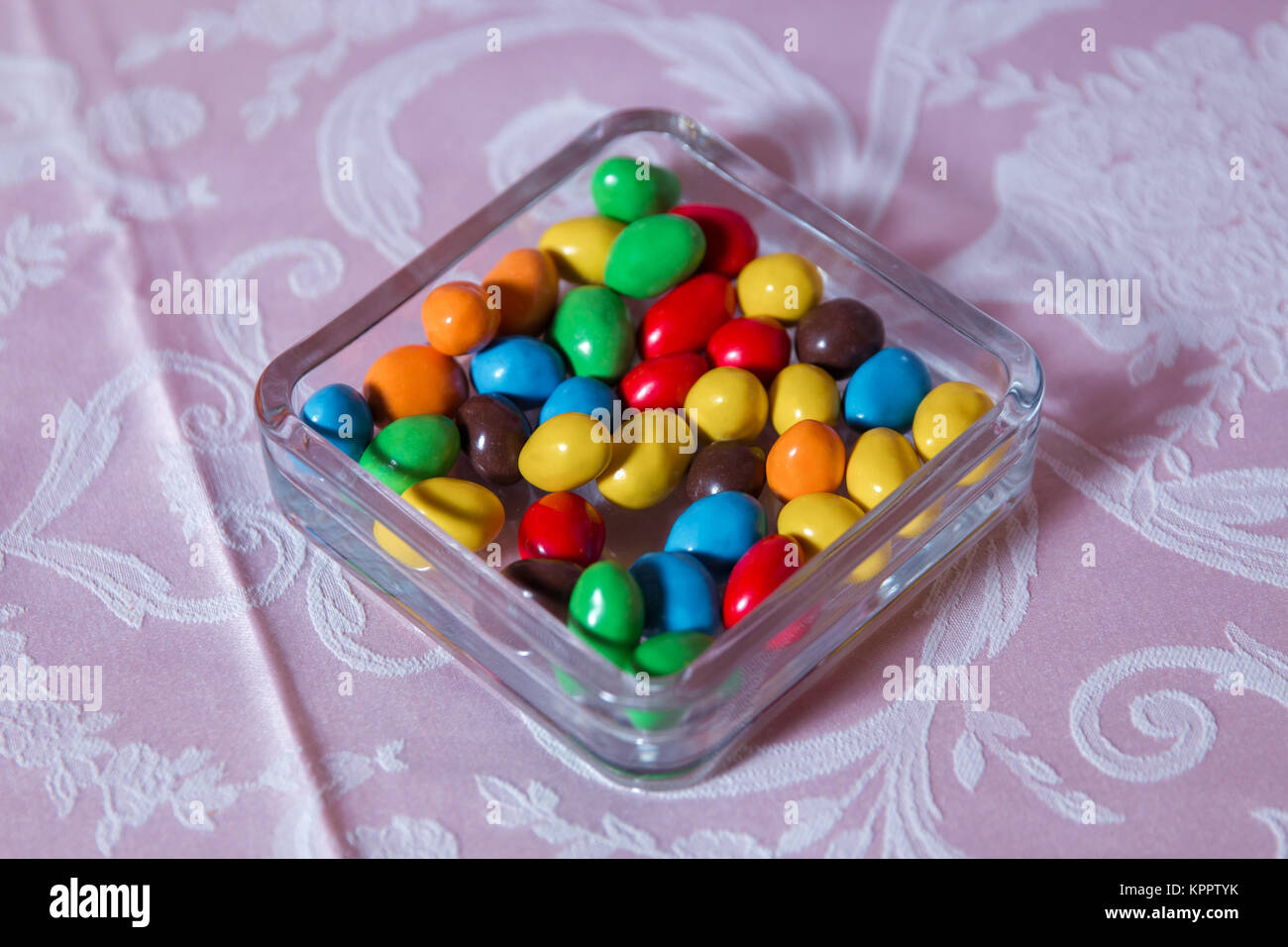 Multi colored sweets . Colored candy in a glass . Round chocolate is ...