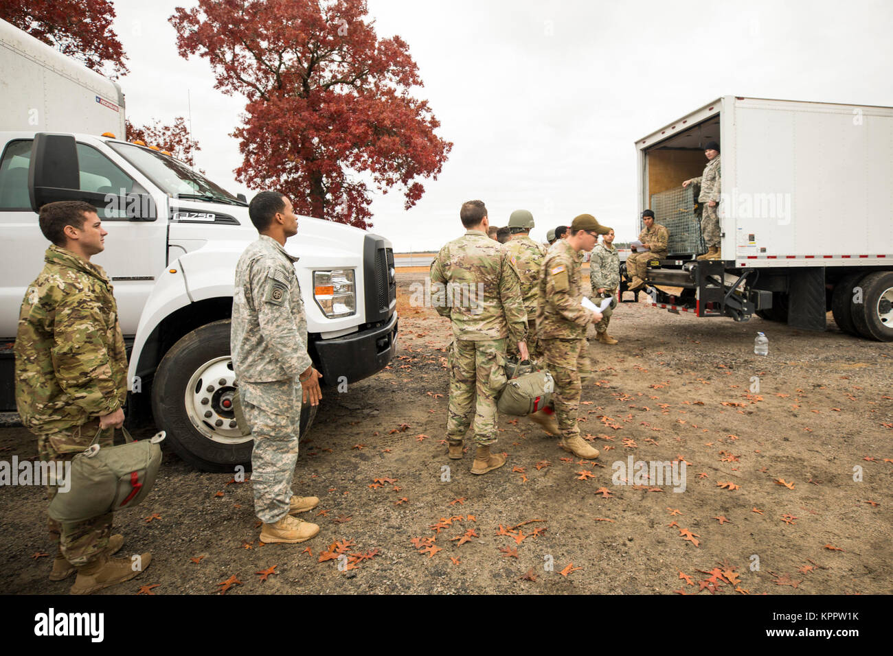 U.S. Army paratroopers stand in line to receive a parachute during the ...