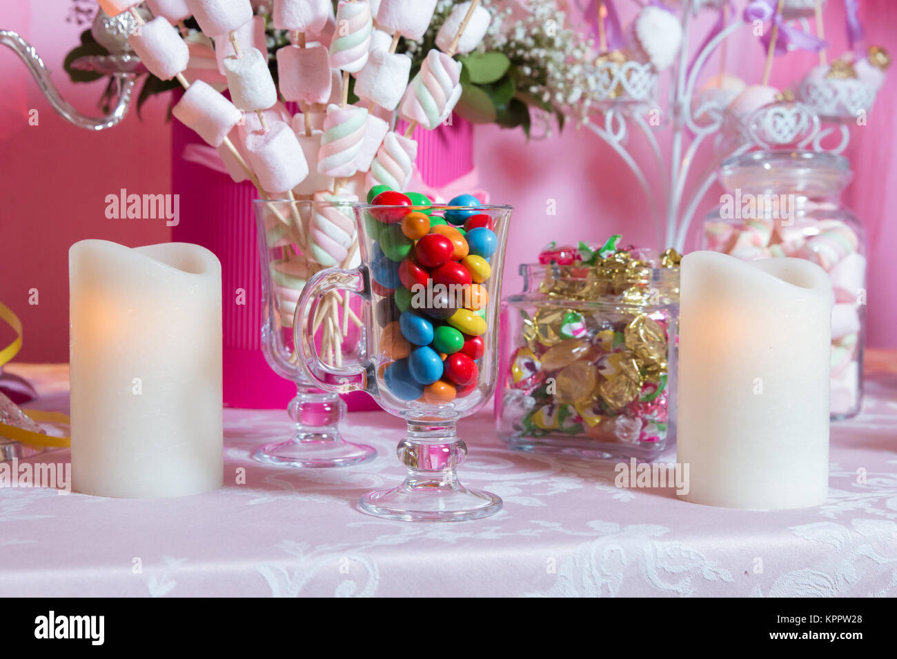 Multi colored sweets . Colored candy in a glass . Round chocolate is ...
