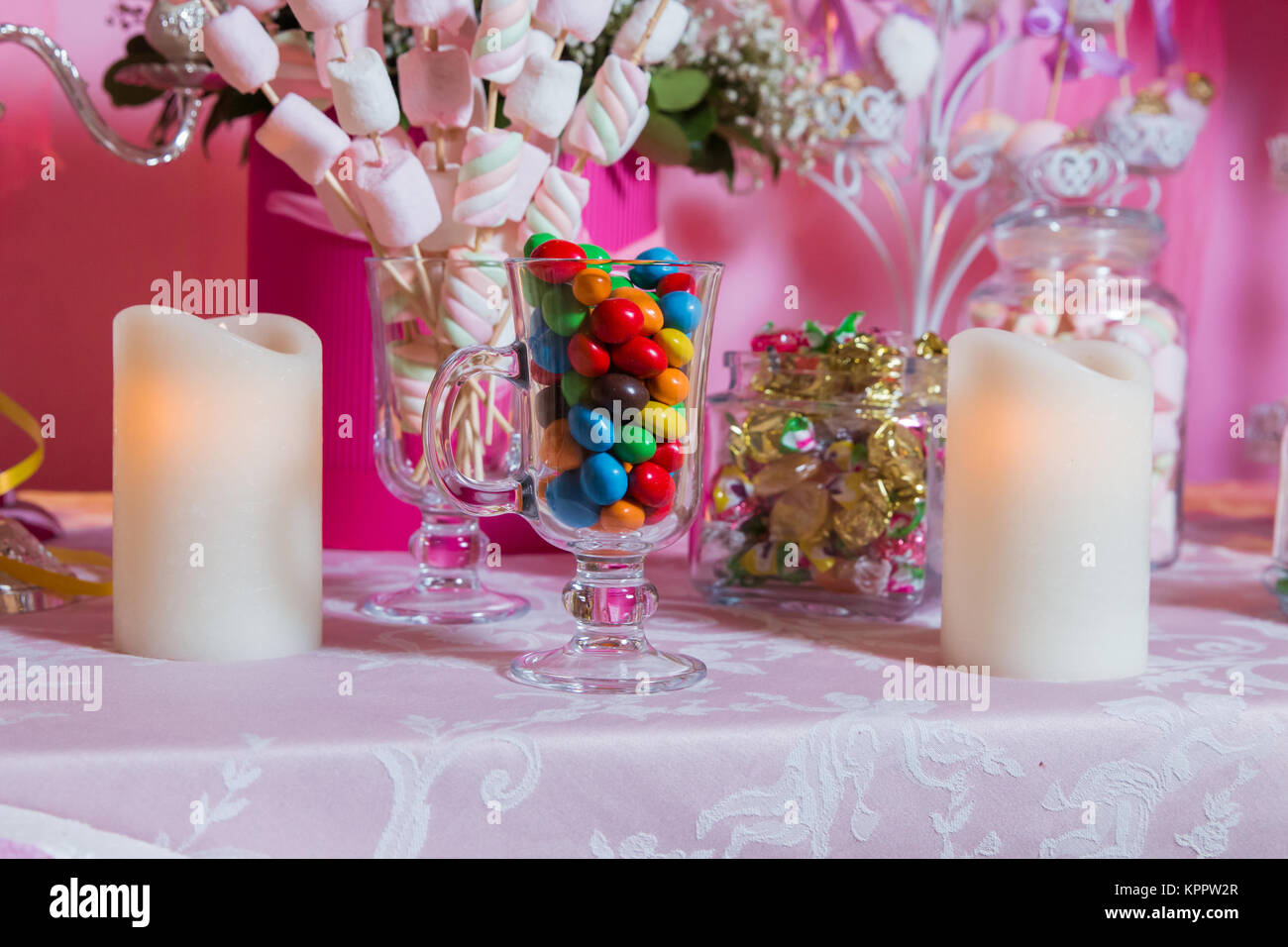 Multi colored sweets . Colored candy in a glass . Round chocolate is ...